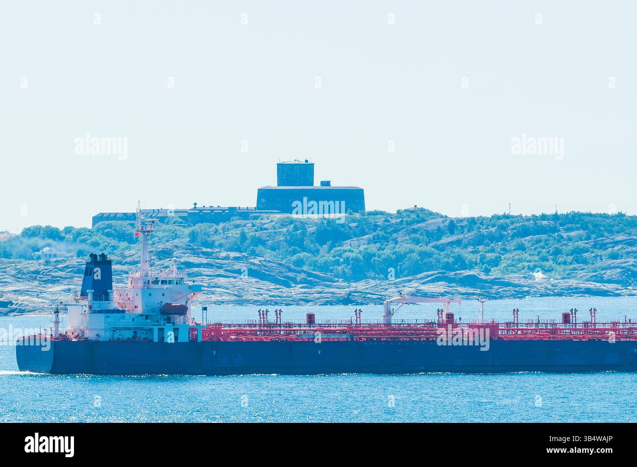 A cargo ship glides across the sparkling blue waters of the Swedish ...