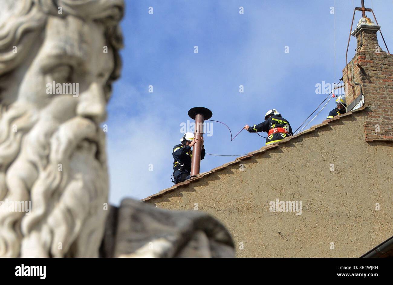 File photo - Vatican's firefighters setup the chimney on the roof of ...