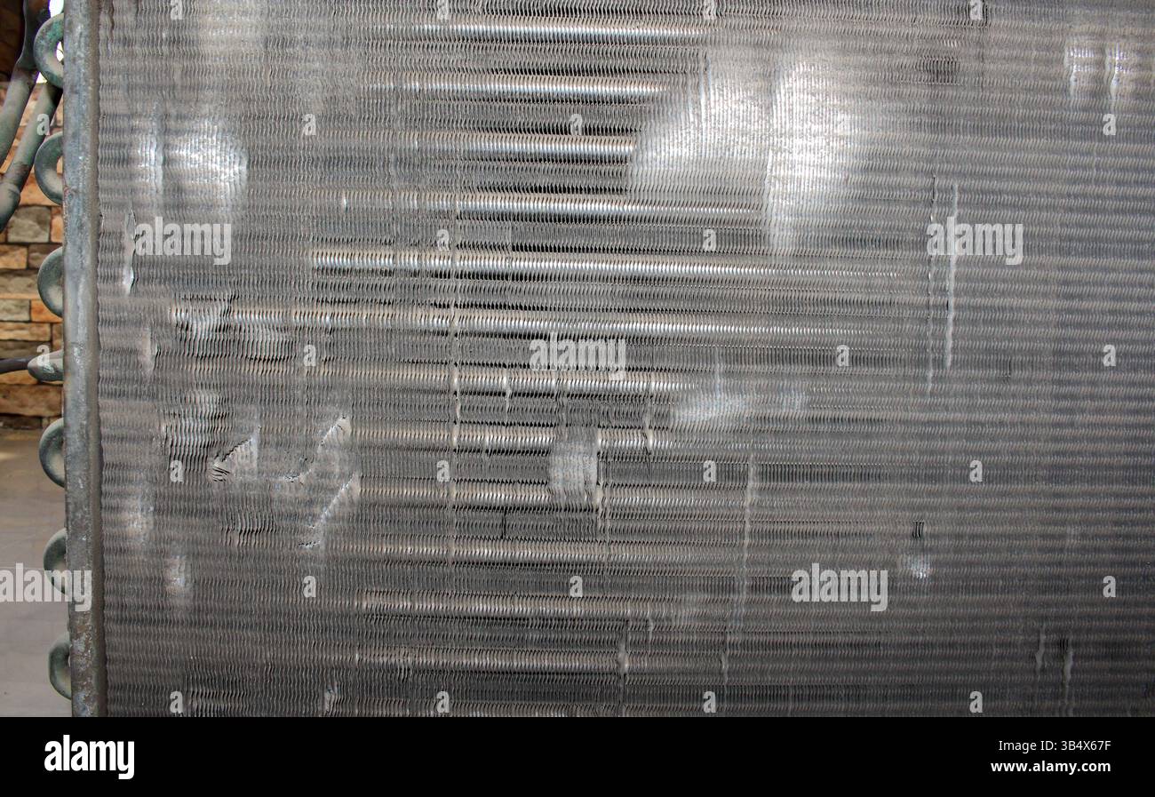 A close-up of a dusty and dirty AC condenser coil, showing years of ...