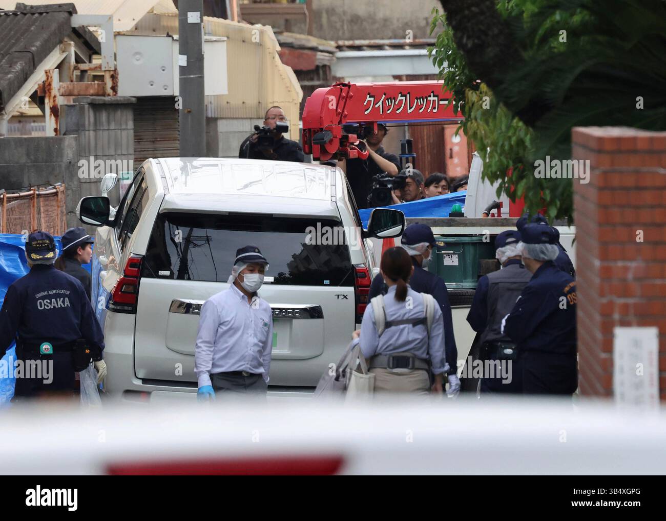 Osaka Prefectural police detectives investigate a car left at a crime ...