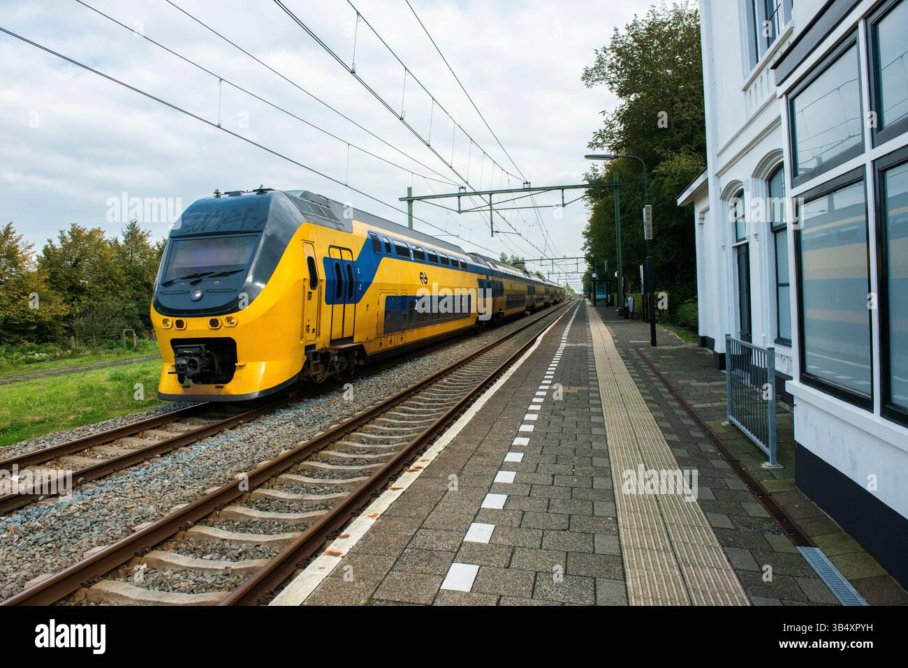 Intercity train arriving at a small, little railway station. Arnemuiden ...