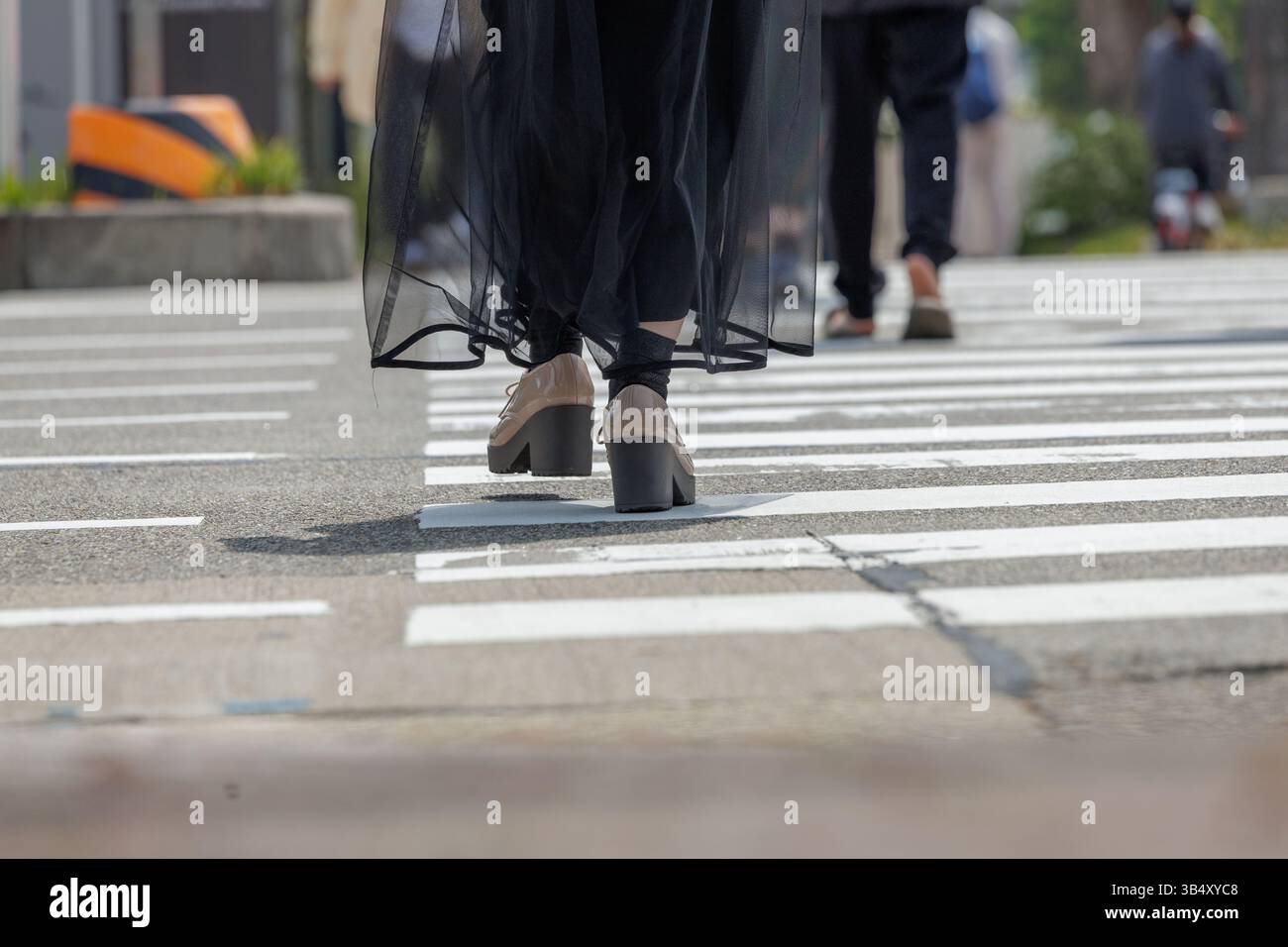 Scene of urban life with people walking in various directions across a ...