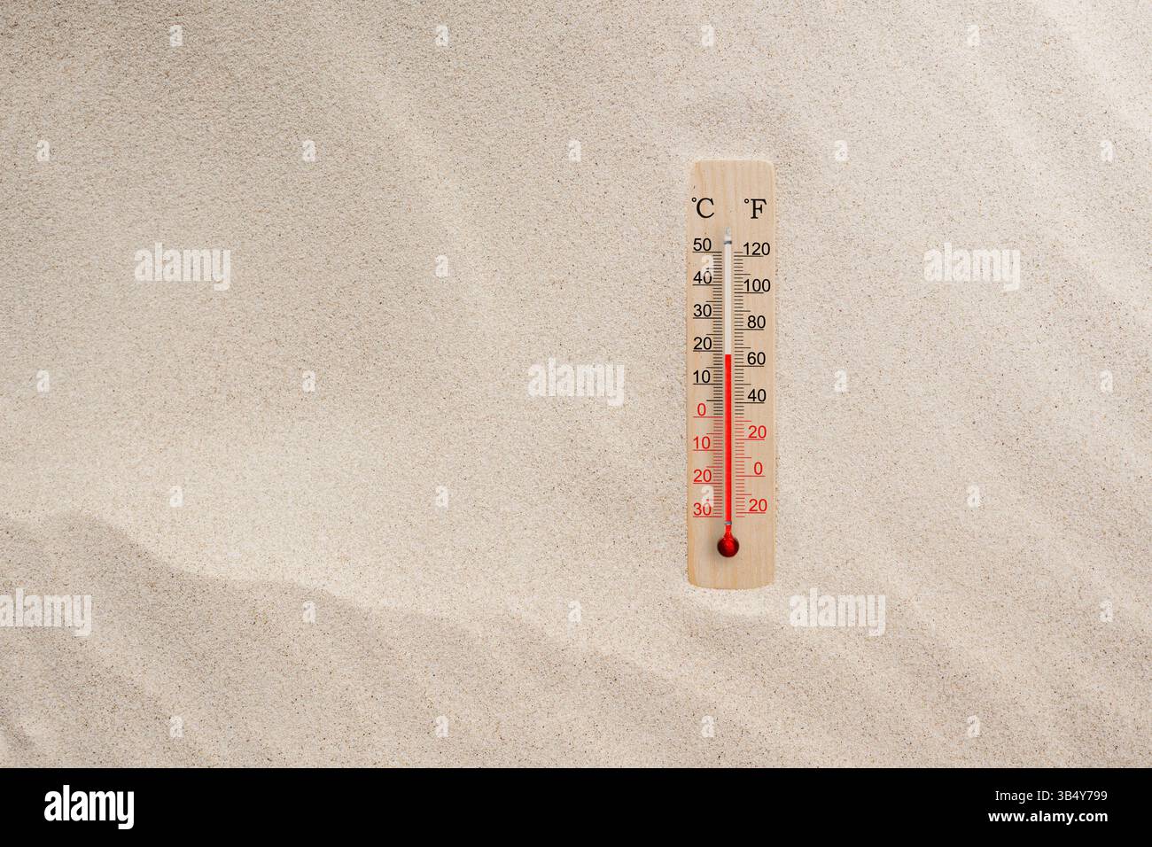 Wooden celsius and fahrenheit scale thermometer in the sand. Ambient ...