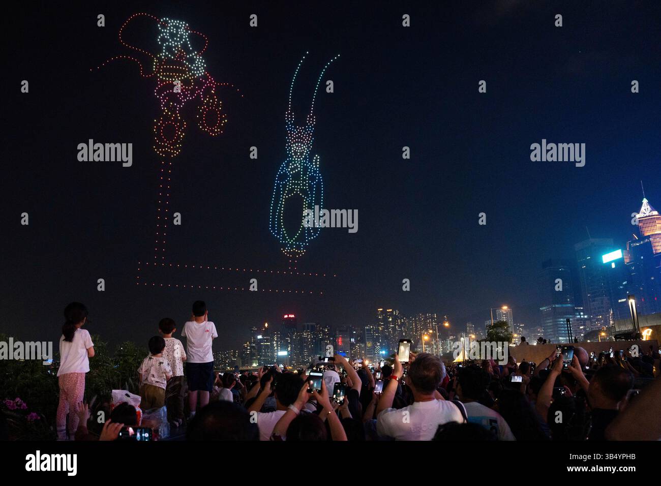 People watch a drone show depicting characters from traditional folk ...