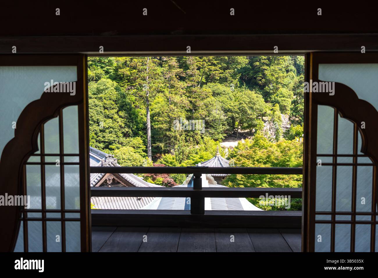 Lush green forest and temple rooftops are beautifully framed by wooden ...