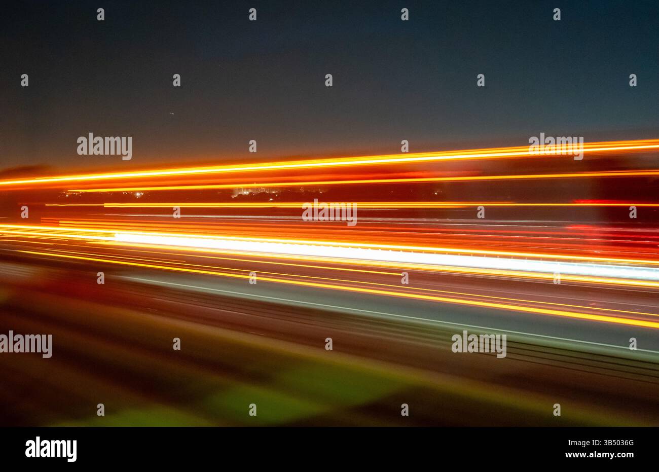 Bright light trails from a moving vehicle create dynamic streaks of red ...