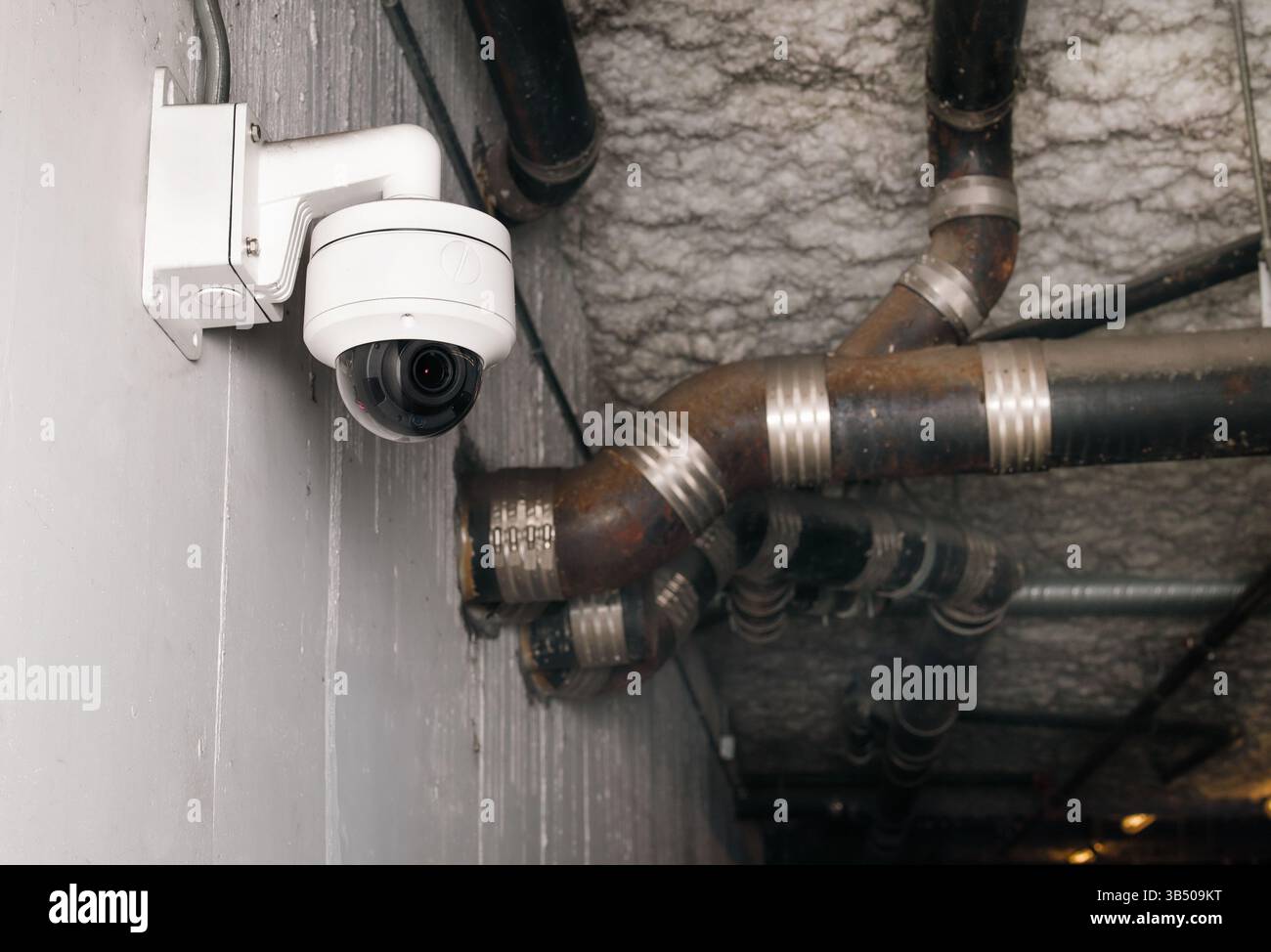 Security camera in parkade of building. Wall mounted dome camera with ...