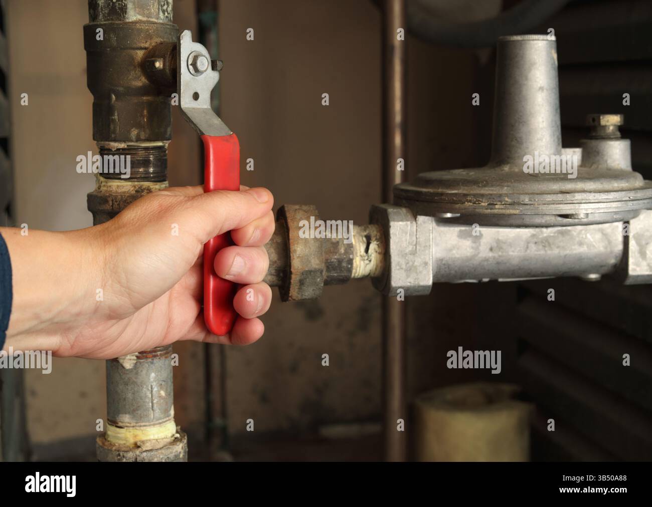Technician using shut-off valve in front of gas pressure regulator ...