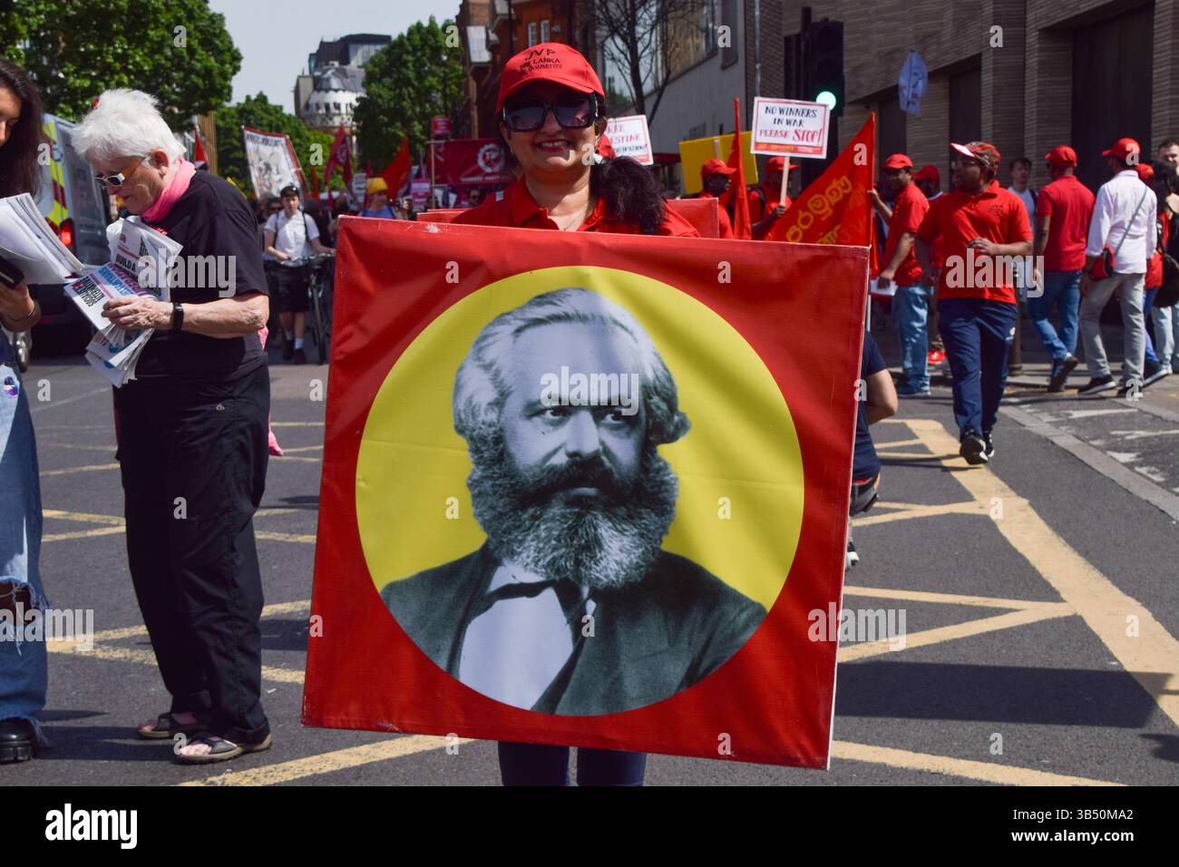 London, UK. 1st May 2025. A protester holds a picture of Karl Marx as ...