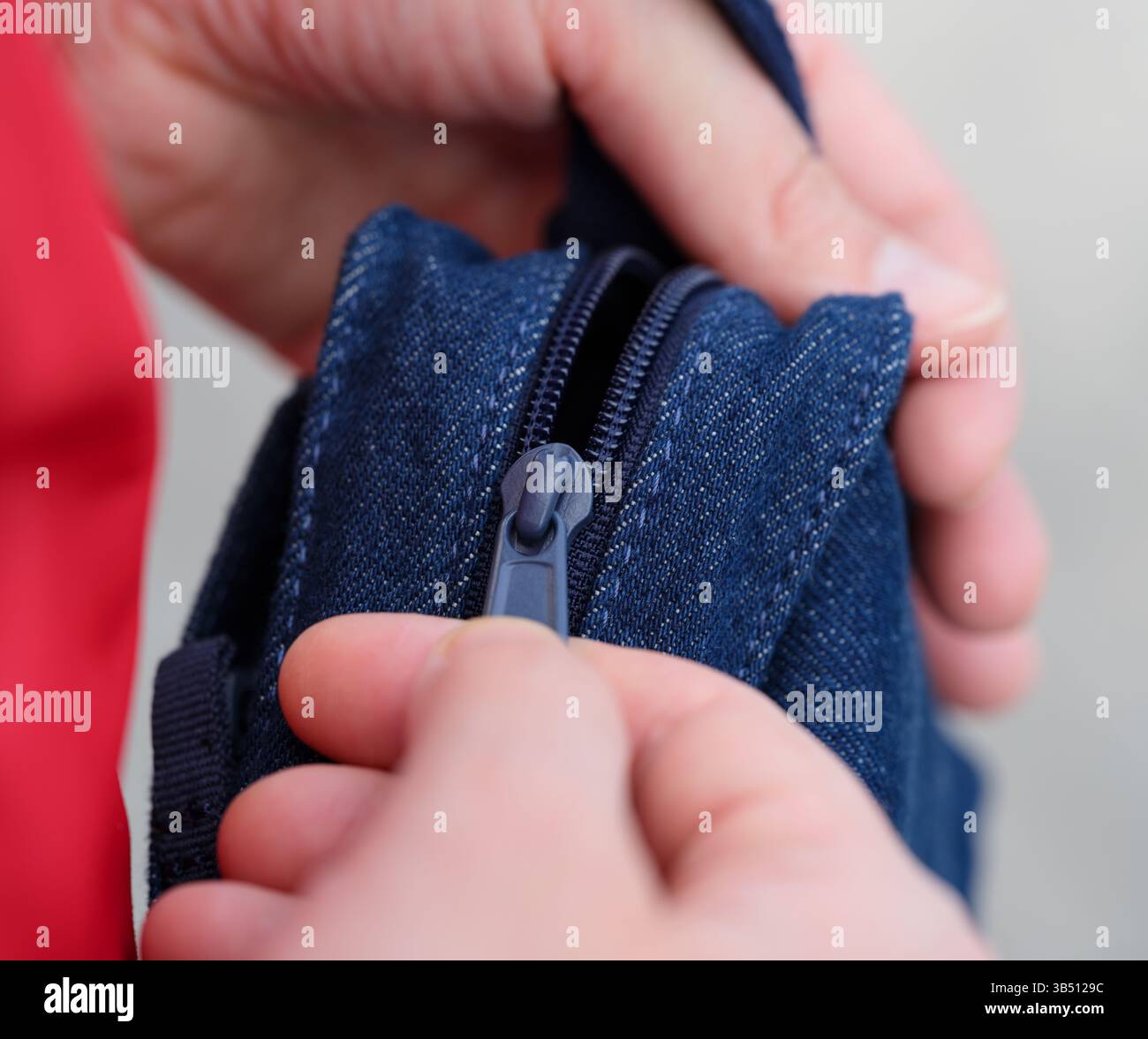 Close-up shot of woman hands using zip on denim bag Stock Photo - Alamy