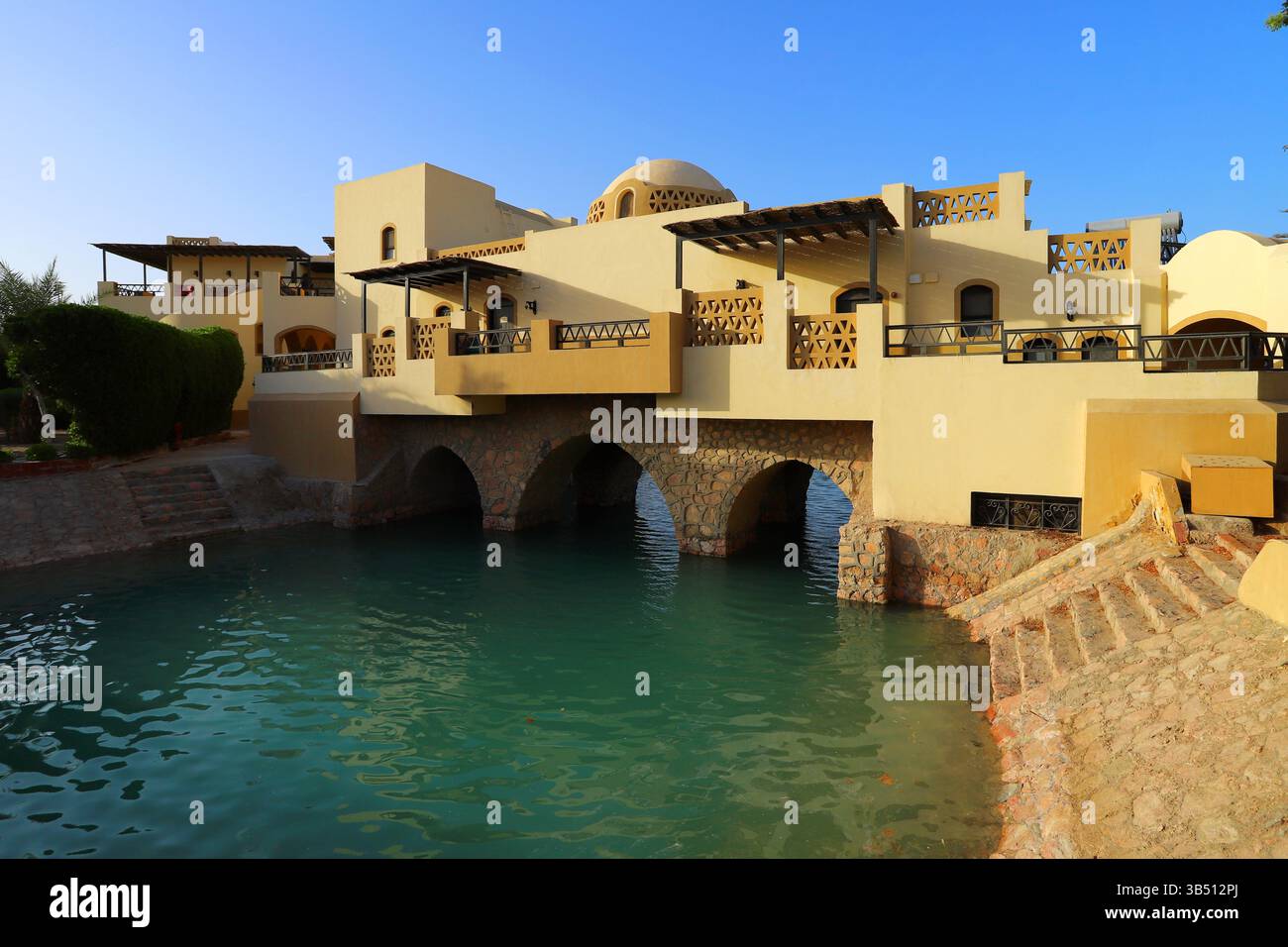 Traditional Nubian-style waterfront building with arched canal passages ...