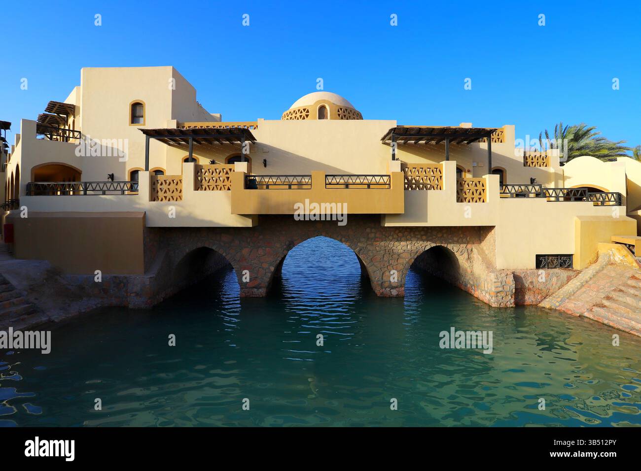 Traditional Nubian-style waterfront building with arched canal passages ...