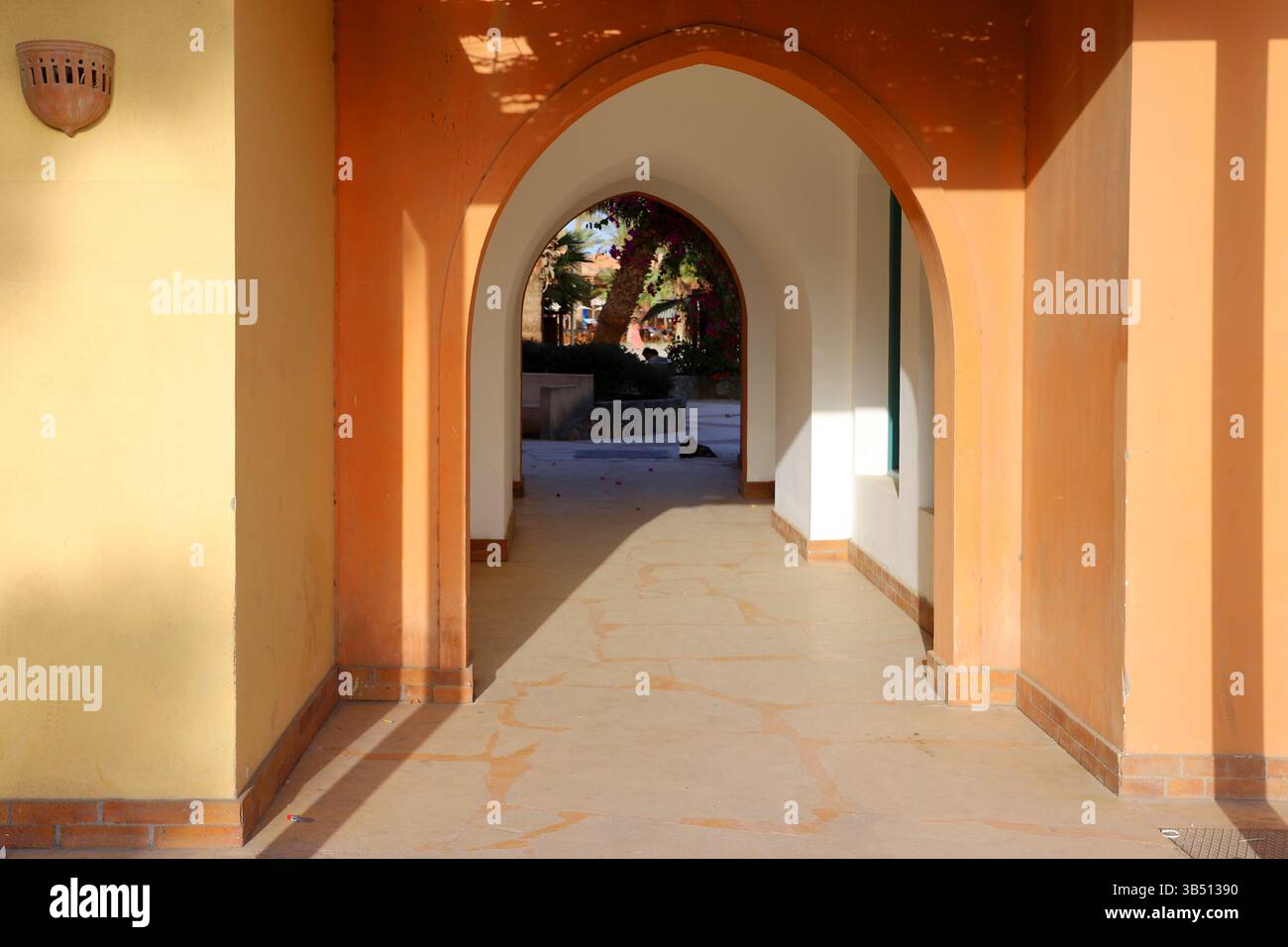 Sunny arcade with arched passageway and warm-colored walls in El Gouna ...