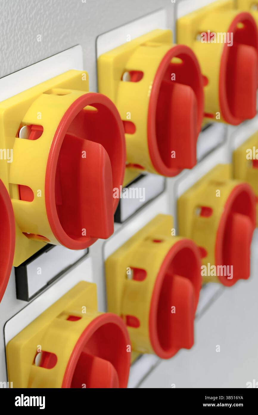 A lot of red and yellow electric switches with white labels on a grey ...