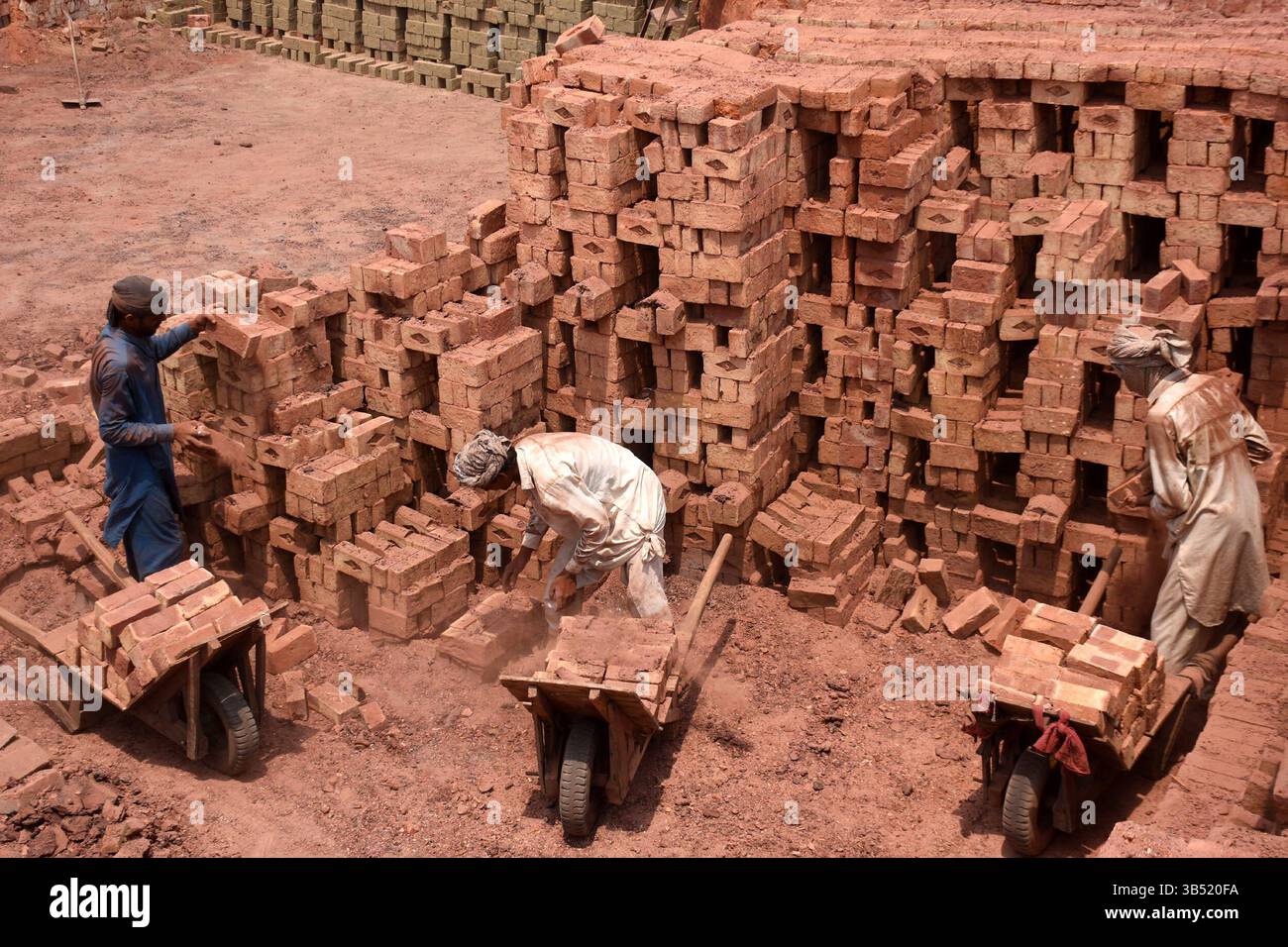 Lahore. 1st May, 2025. Laborers work at a brick kiln in Lahore ...