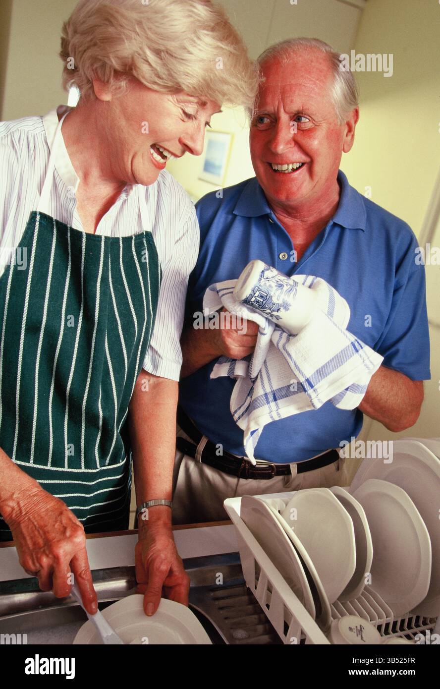 Senior couple washing dishes in the kitchen at home Stock Photo - Alamy