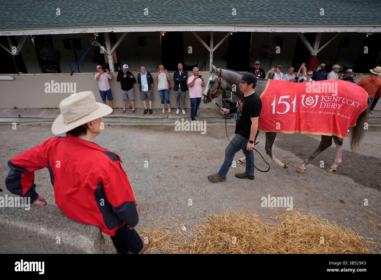 People watch as Kentucky Derby entrant Sandman walks back to its barn ...