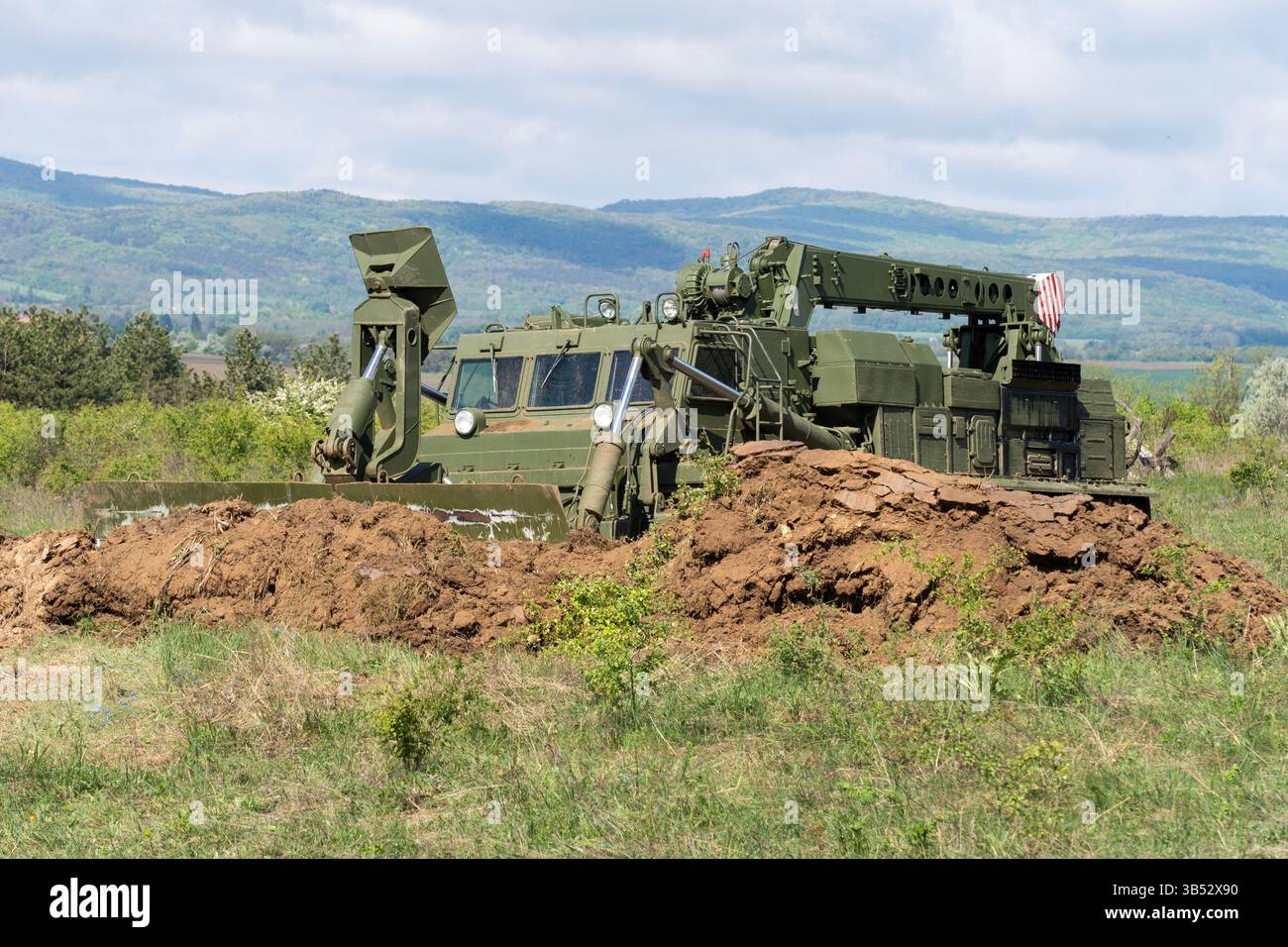 Green military engineering vehicle with crane and bulldozer blade Stock ...