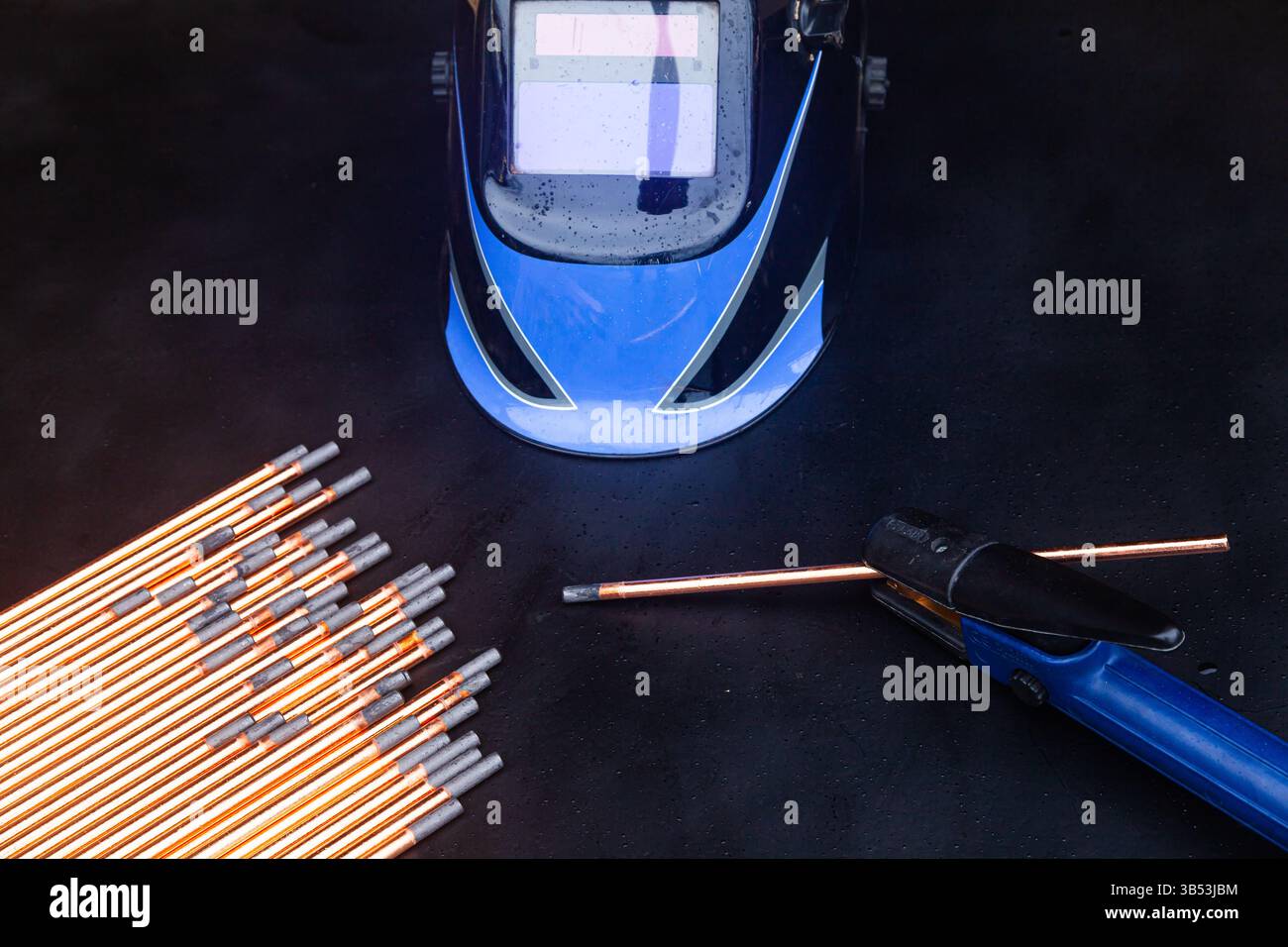 Graphite gouging electrodes with holder and welding mask on black ...