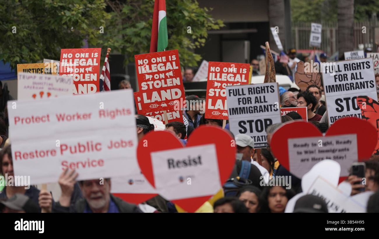 Demonstrators hold signs during a May Day protest Thursday, May 1, 2025 ...