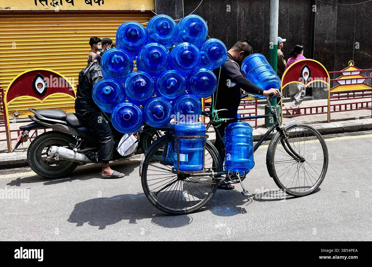 May 1, 2025: Kathmandu, Nepal: A man carries empty water jars on his ...