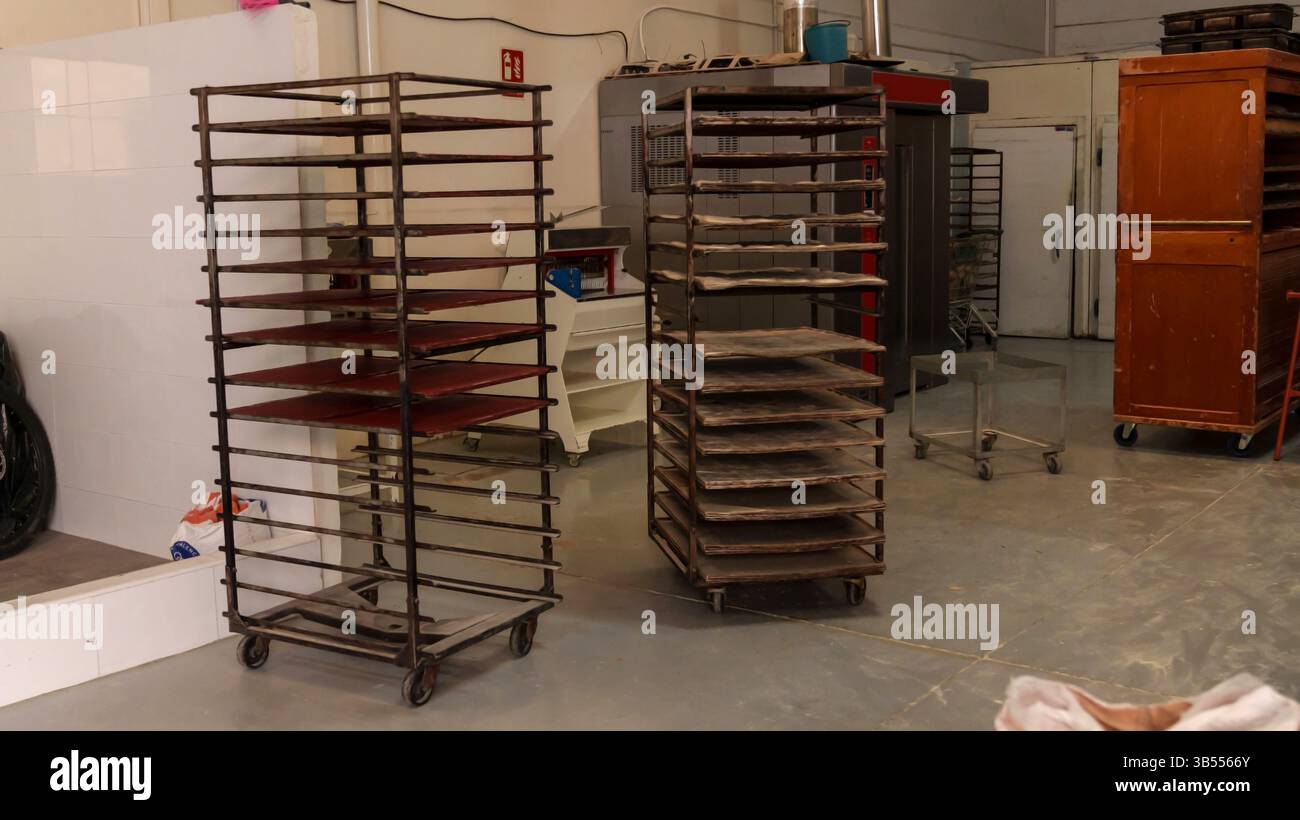 Industrial baking racks with multiple trays in a spacious bakery ...