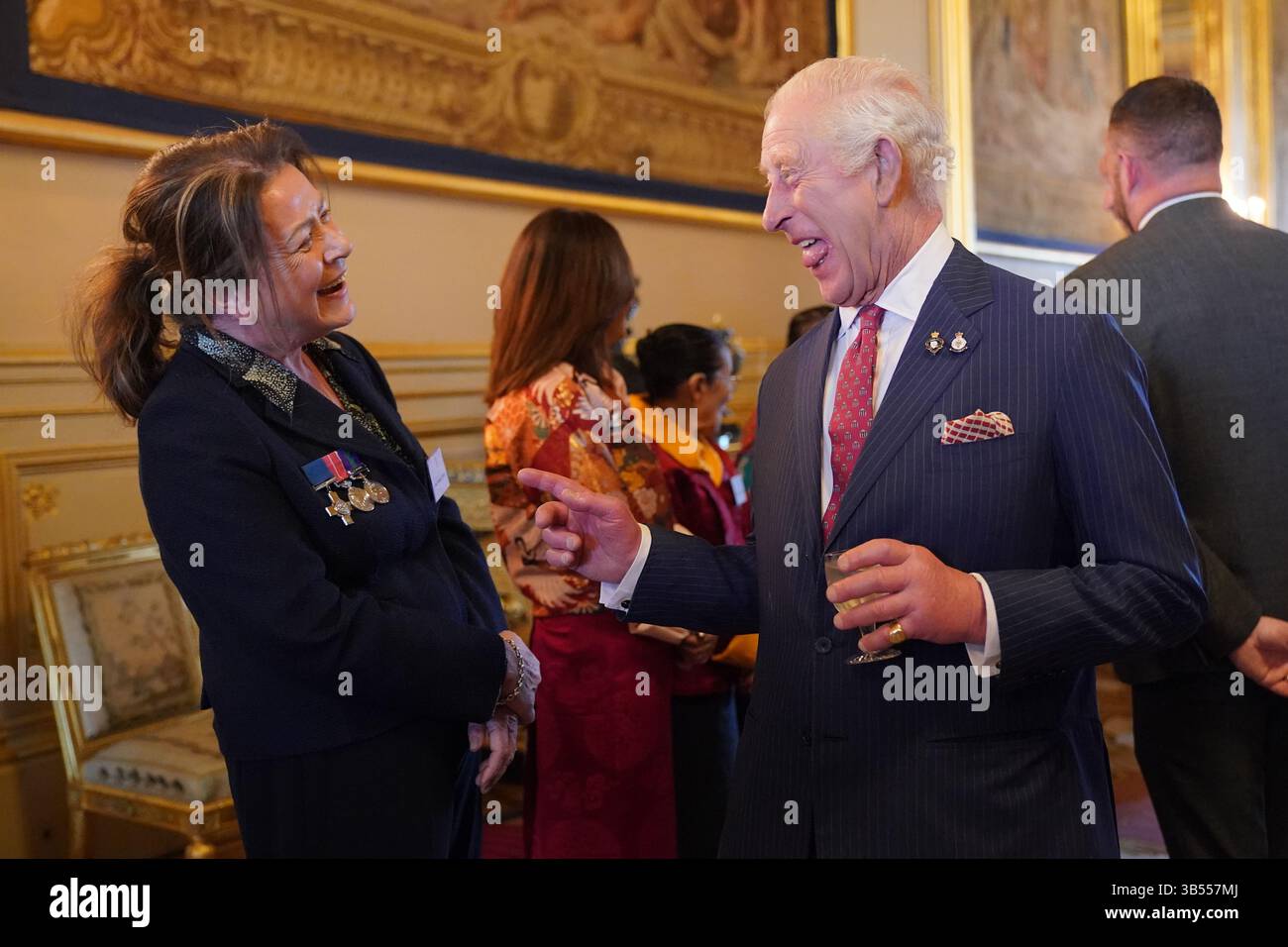 King Charles III laughing whilst talking to Nichola Stanley during a ...