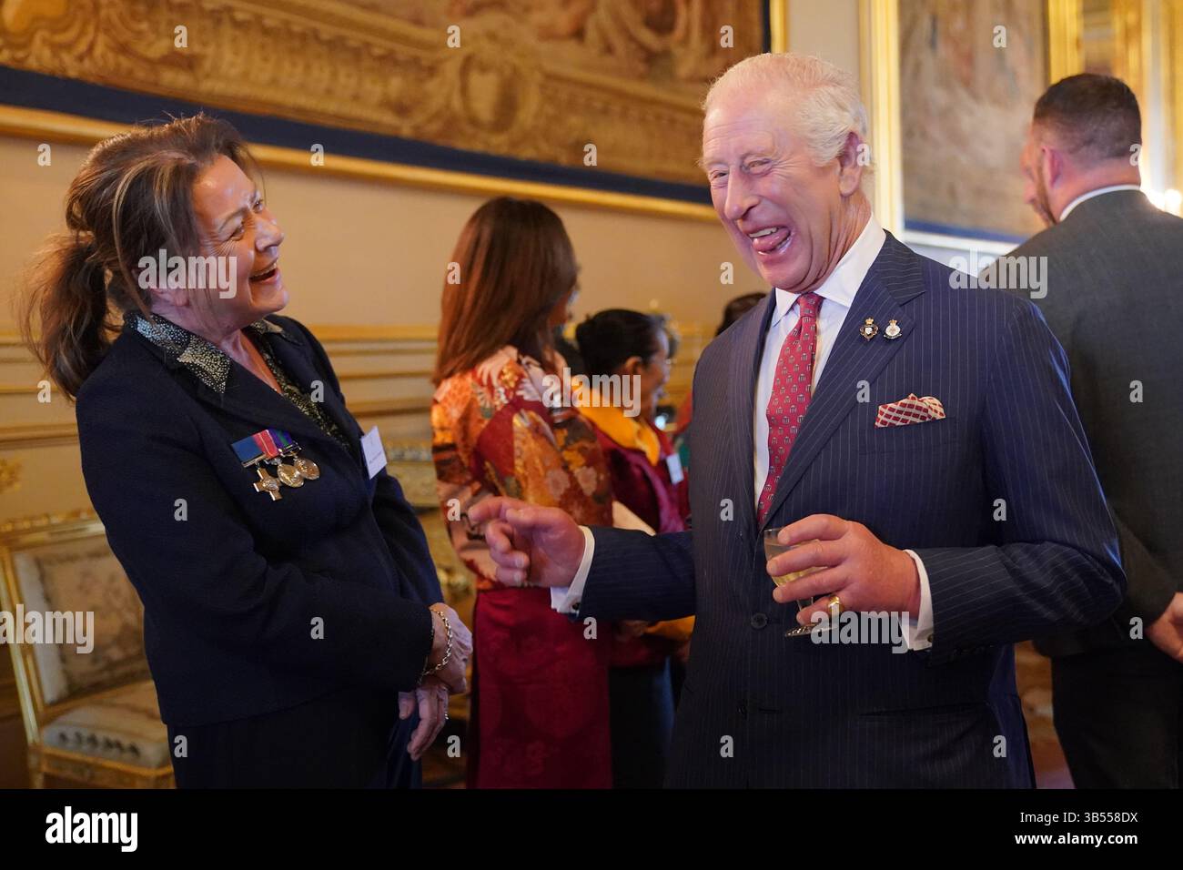 King Charles III laughing whilst talking to Nichola Stanley during a ...