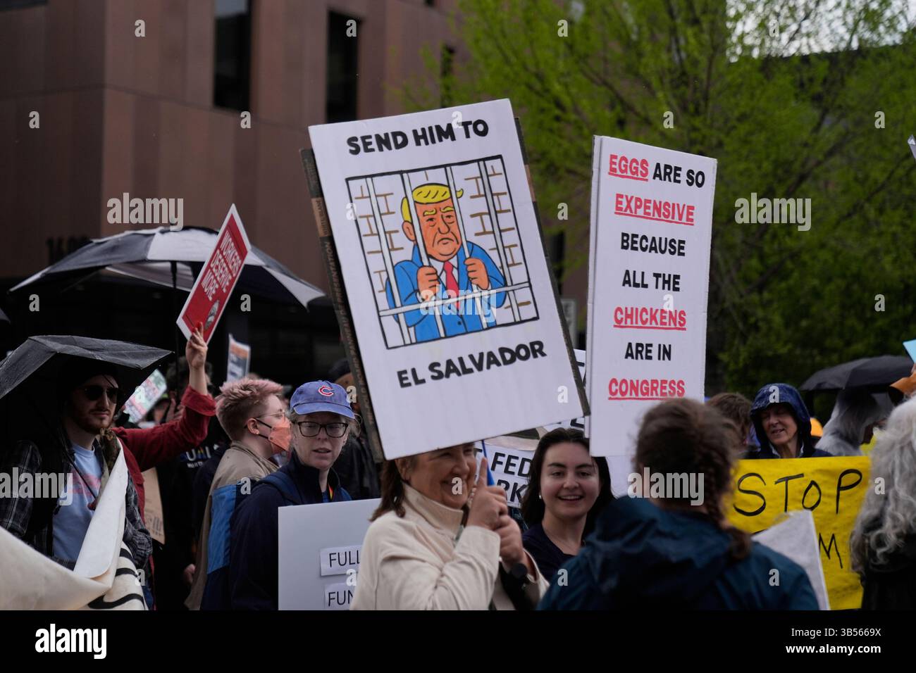 Protesters carry signs as thousands of people march in a May Day rally ...