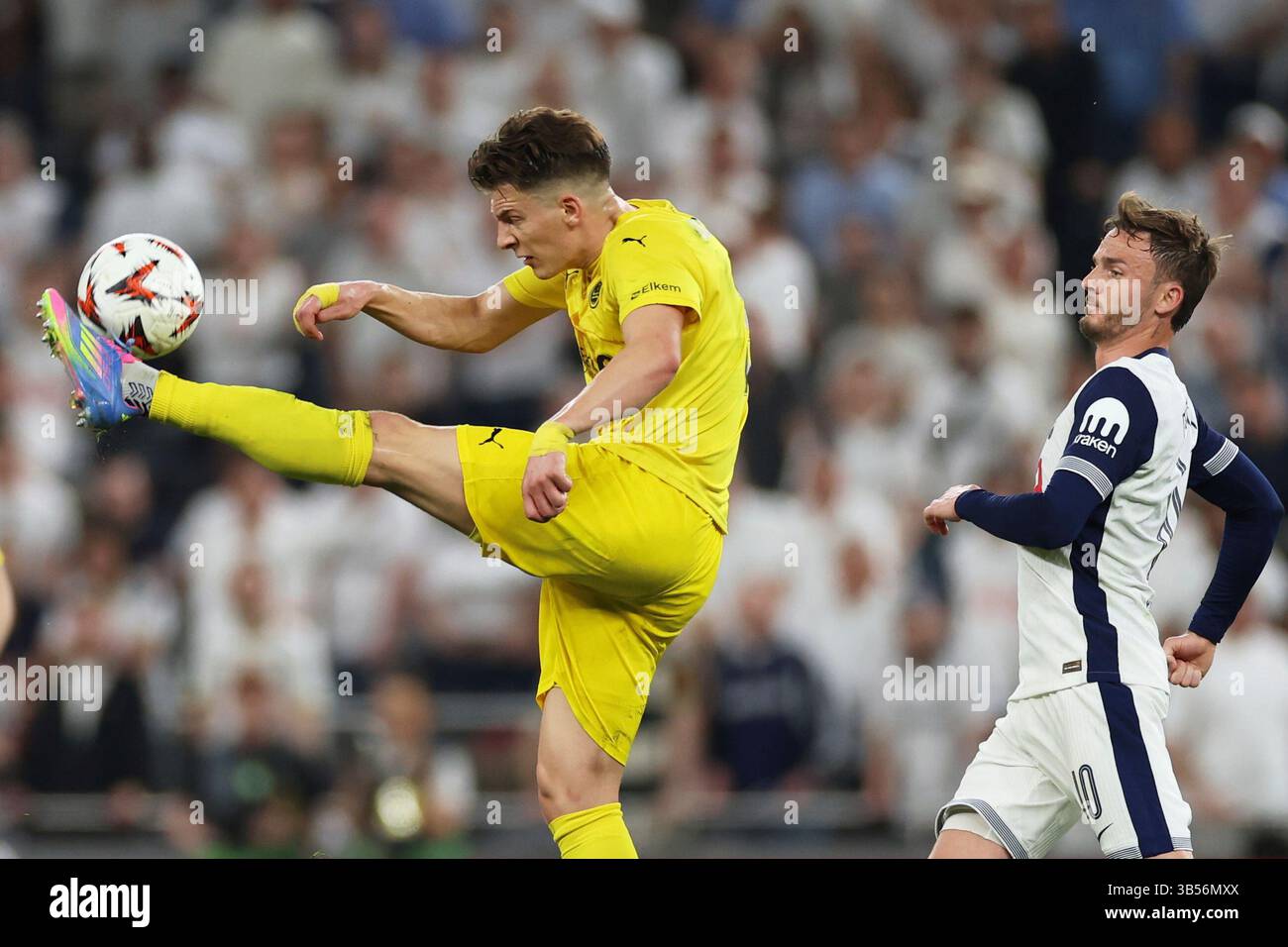 Glimt's Jostein Gundersen, left, clears the ball past Tottenham's James ...