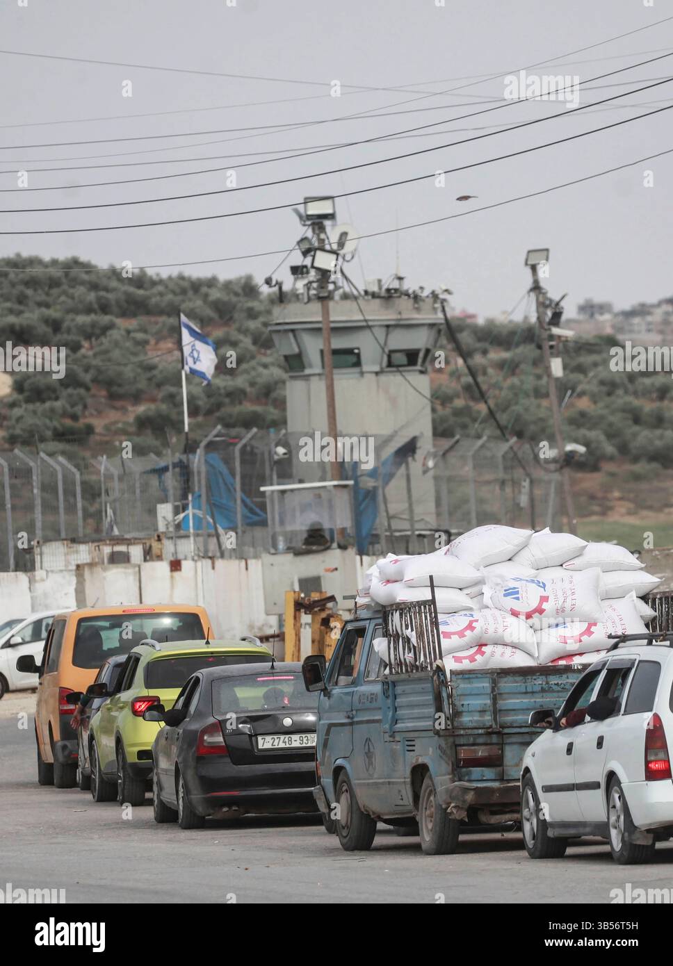 Palestinians vehicles wait at a checkpoint around the West Bank city of ...