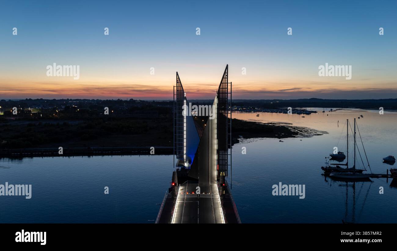 Modern lifting bridge rising at sunset over Holes Bay in Poole, Dorset ...