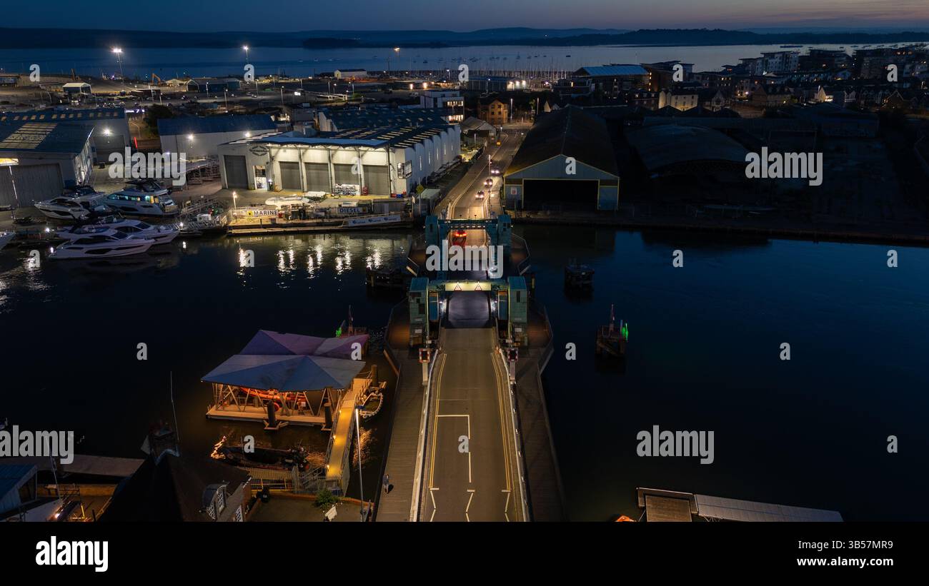 Aerial view of a lifting bridge opening at night, allowing boats to ...