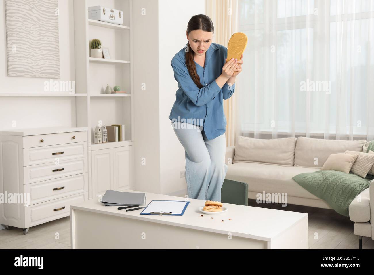 Young woman with slipper looking in disgust at cockroaches on white ...