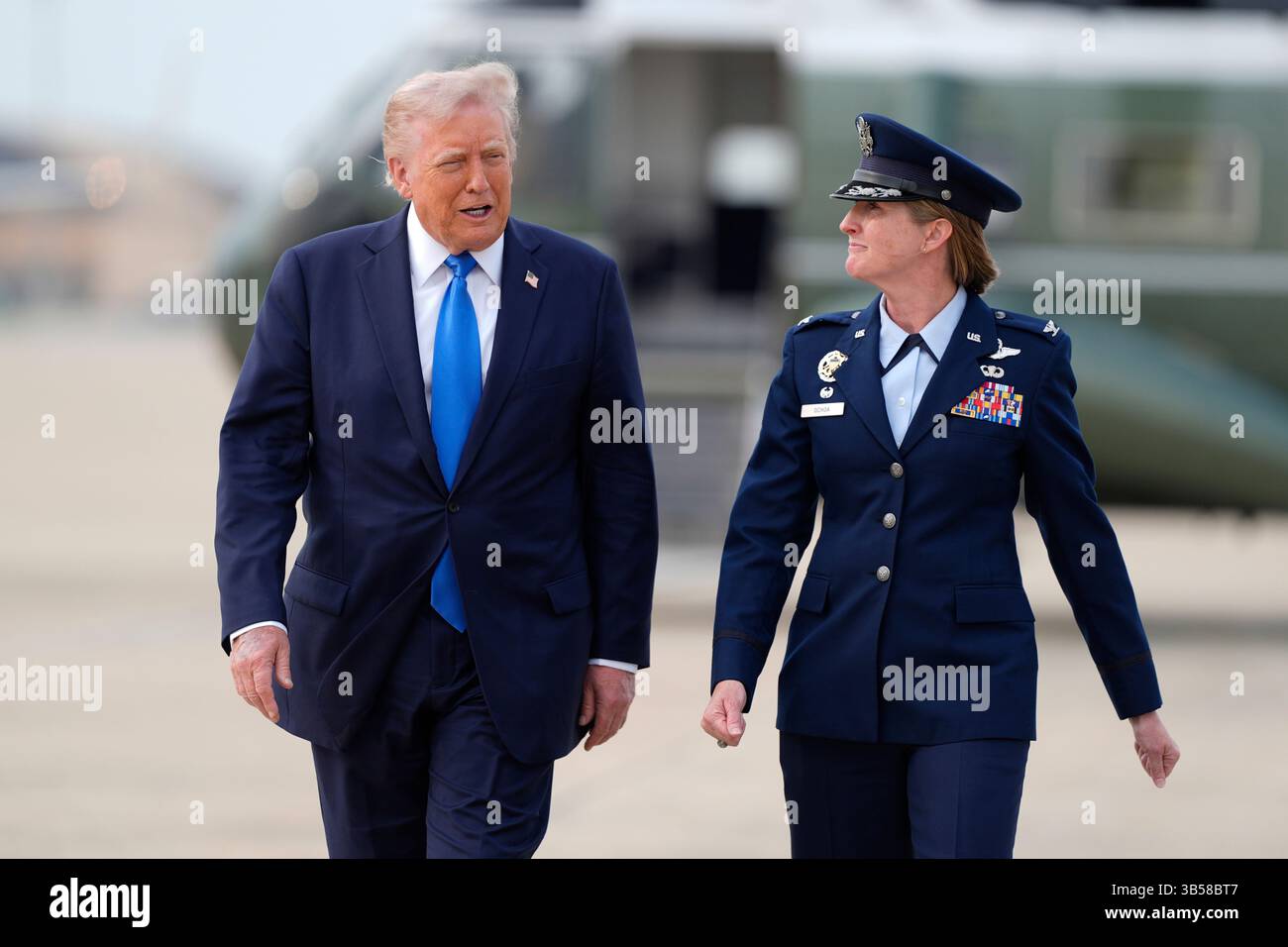 President Donald Trump walks with Air Force Col. Angela Ochoa ...