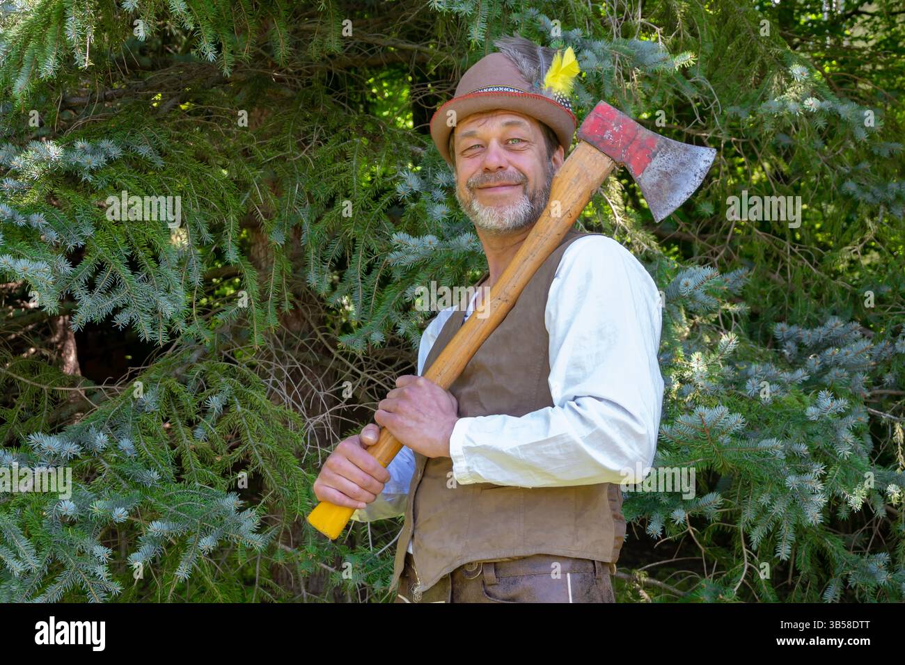 Austrian woodcutter in traditional Tyrolean clothing with an axe on his ...