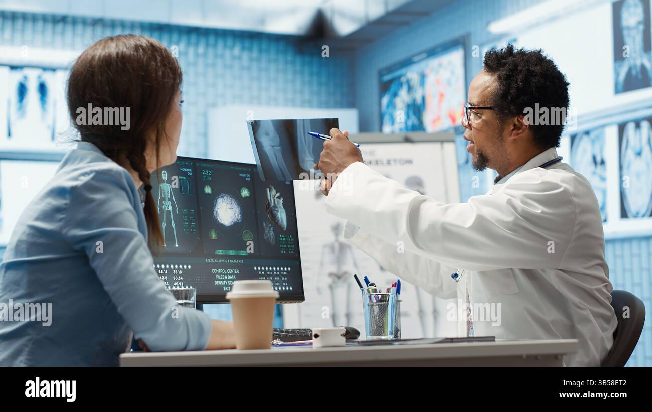 General practitioner examining x ray scan test results with patient ...