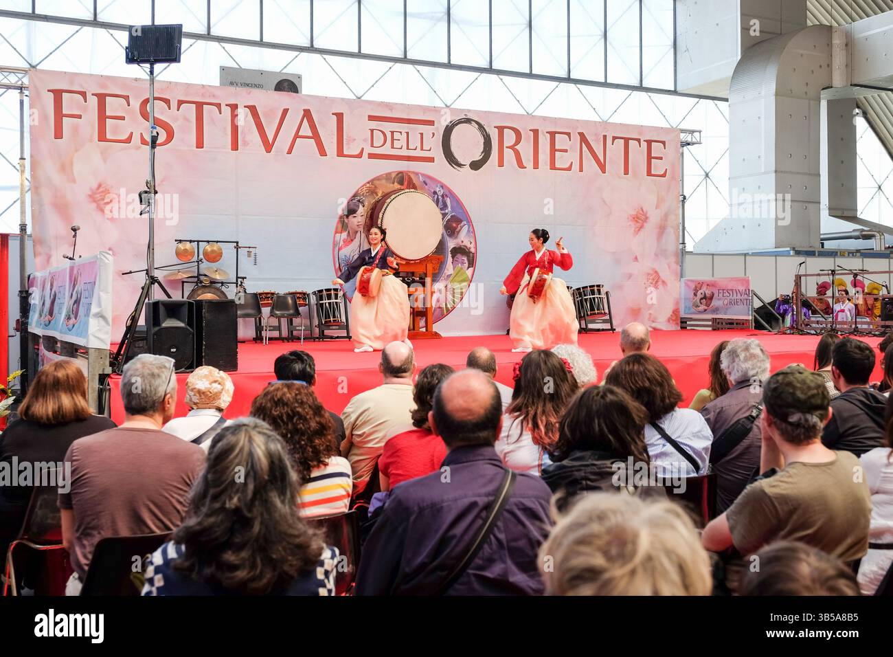 Milan, Italy. 1 May, 2025. Two performers in traditional Korean hanbok costumes dance on stage ...