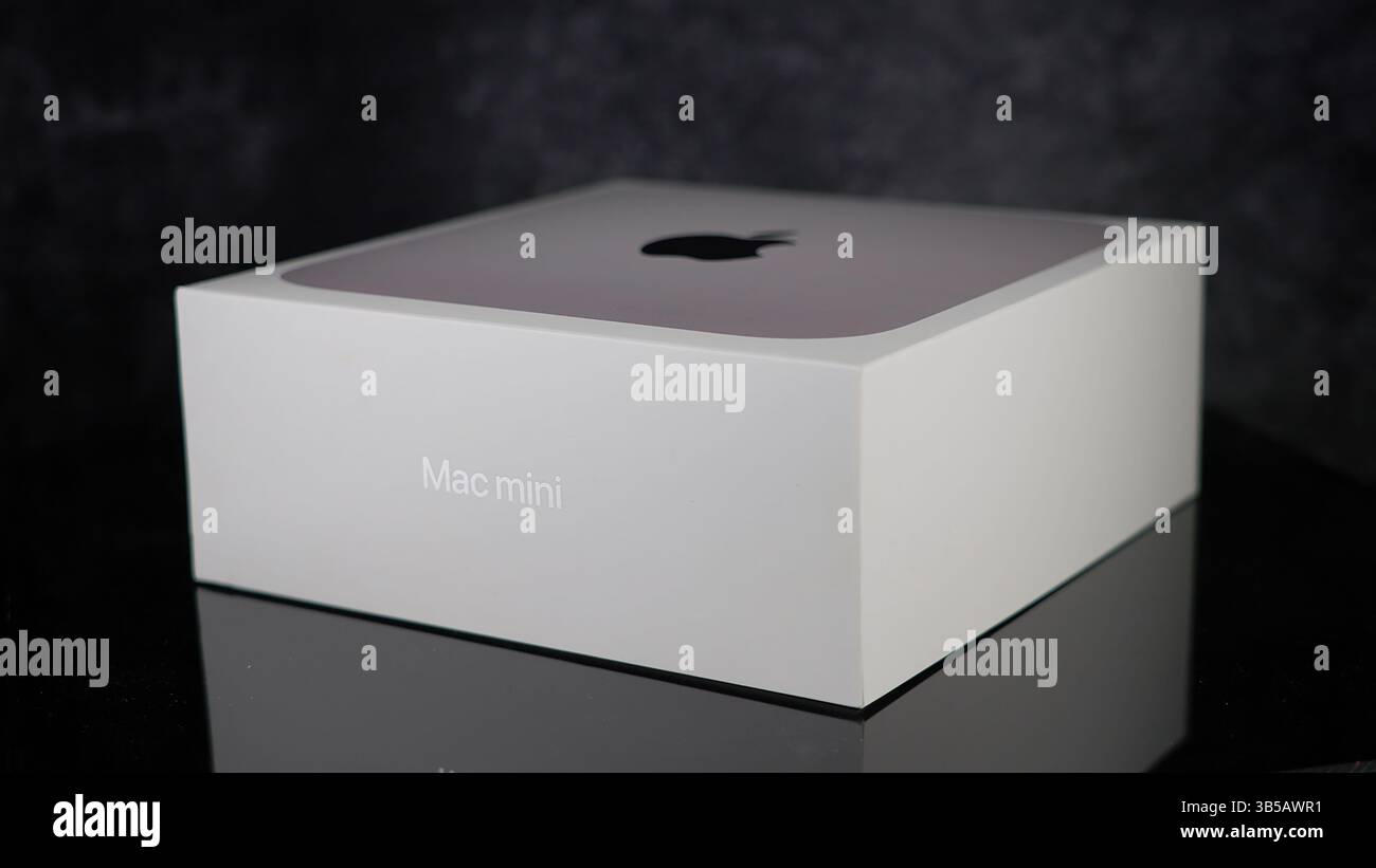 New Apple Mac mini M1 chip computer in a box reflecting on dark glass ...