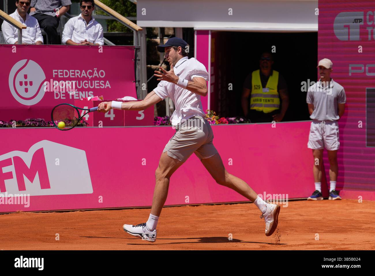 Nicolas Jarry (C) returns a ball to Gastao Elias during the first round ...