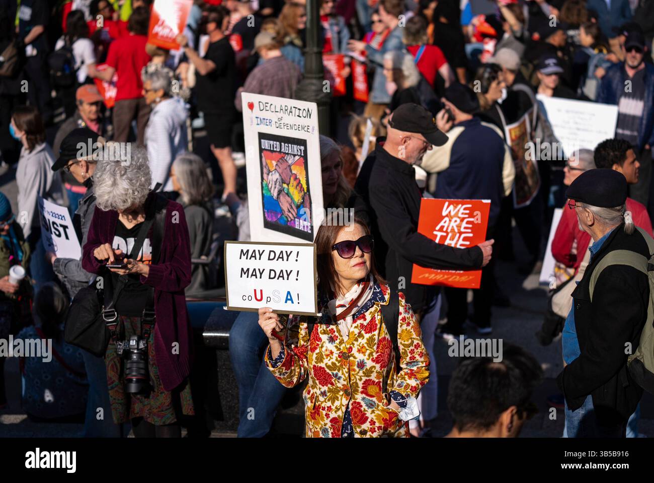 People hold signs and protest during the NYCLU's May Day rally for ...
