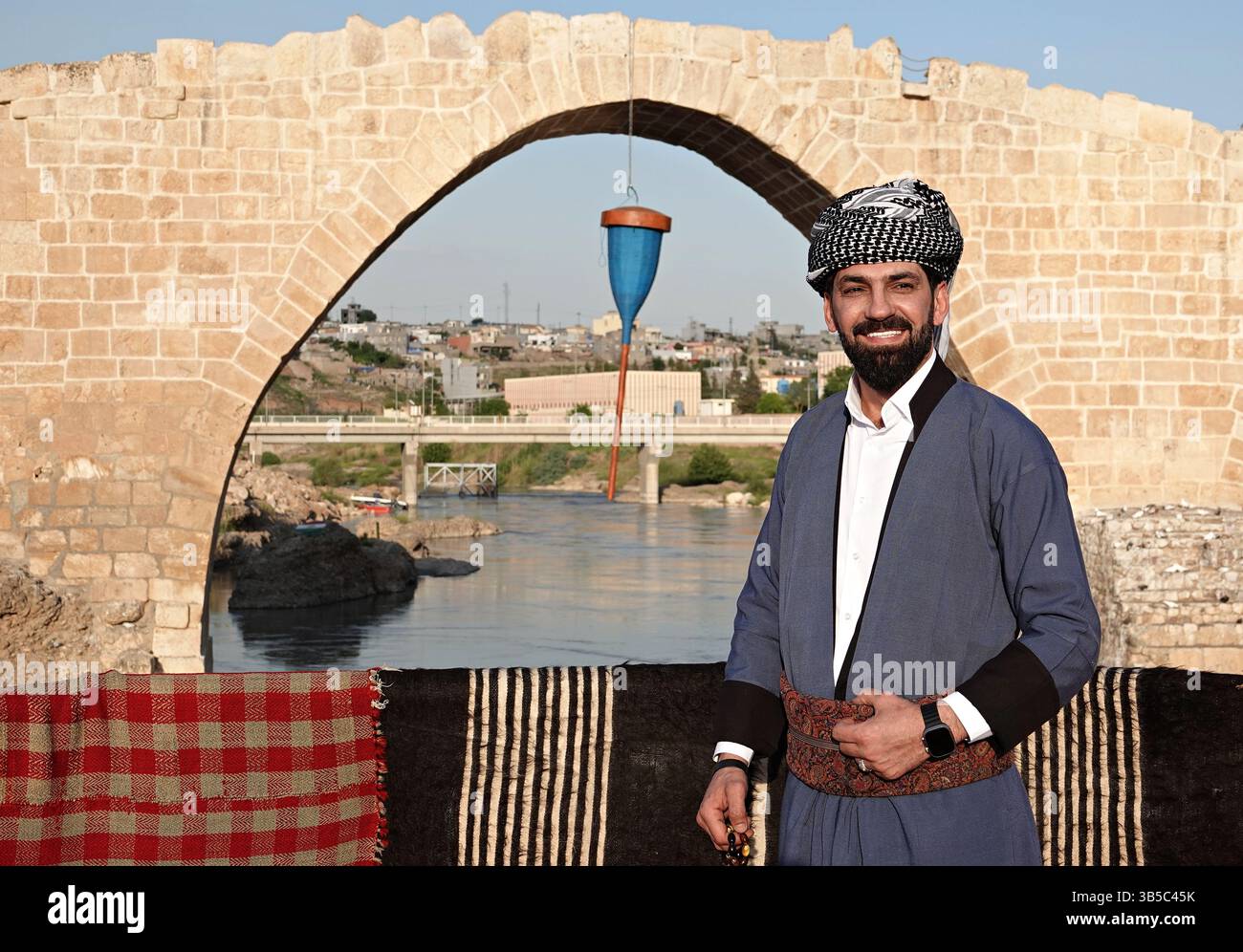 A Kurdish teenager is seen in traditional dress in front of the ...