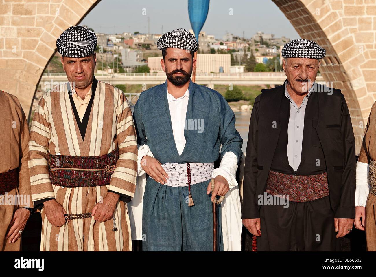 At the festival in Zakho, three Kurds are seen displaying three ...