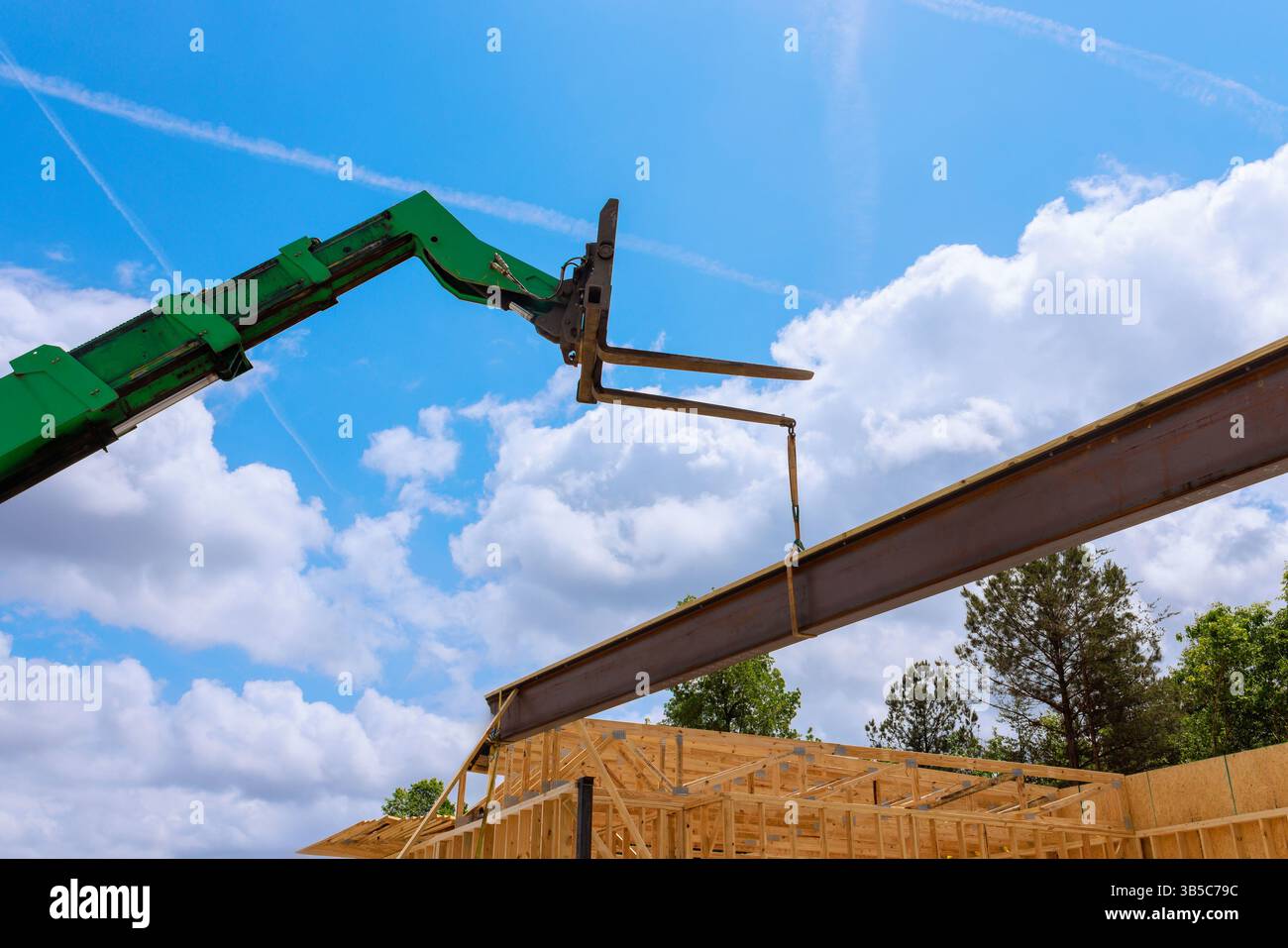 Heavy crane telehandler is lifting steel beam at construction site ...