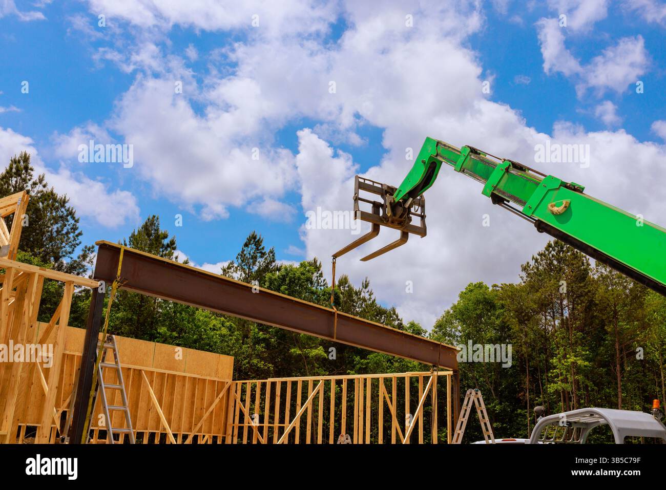 Telehandler crane carefully hoists steel beam into place at ...