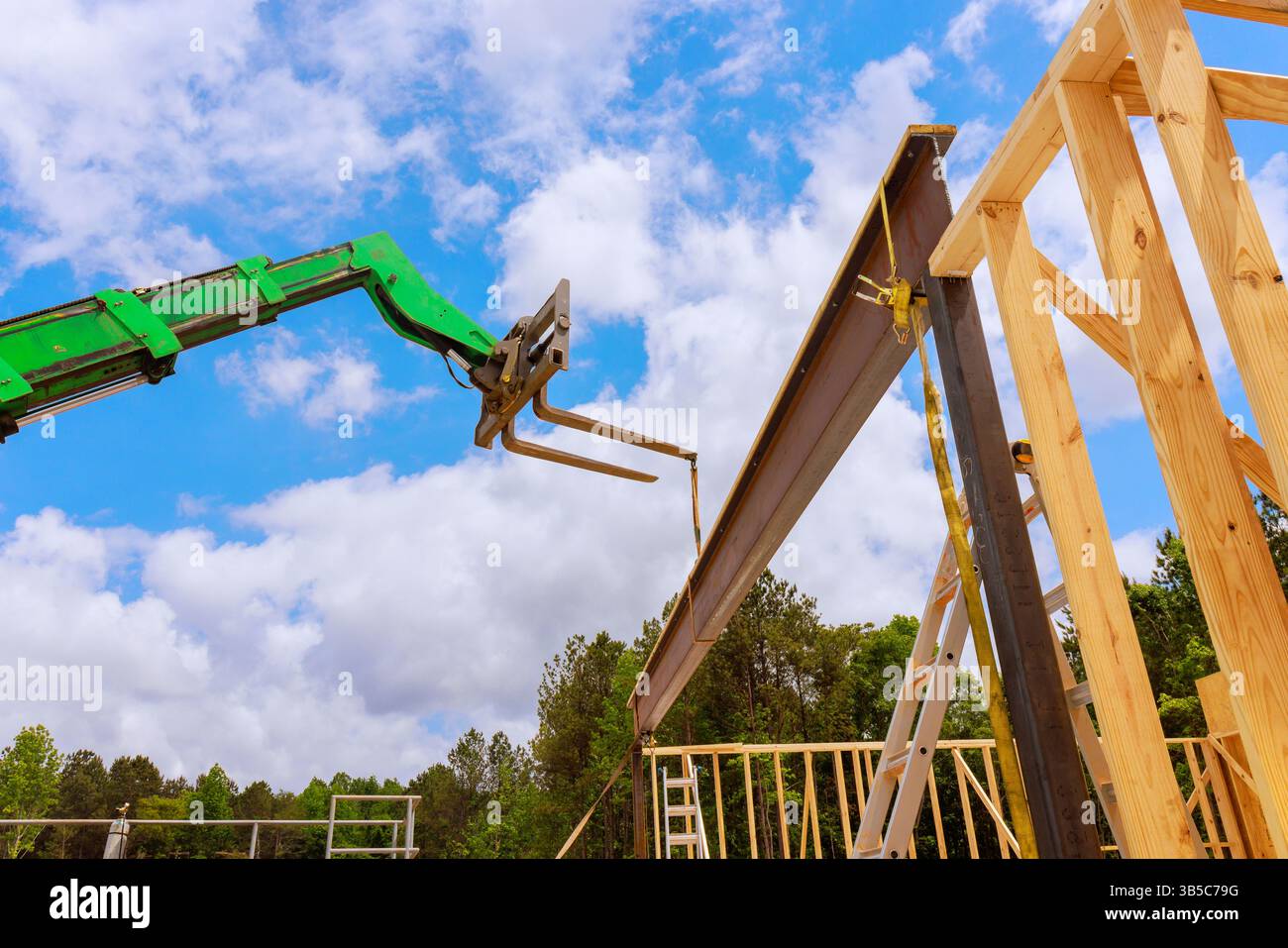 Telehandler construction crane is lifting steel beam into position at ...