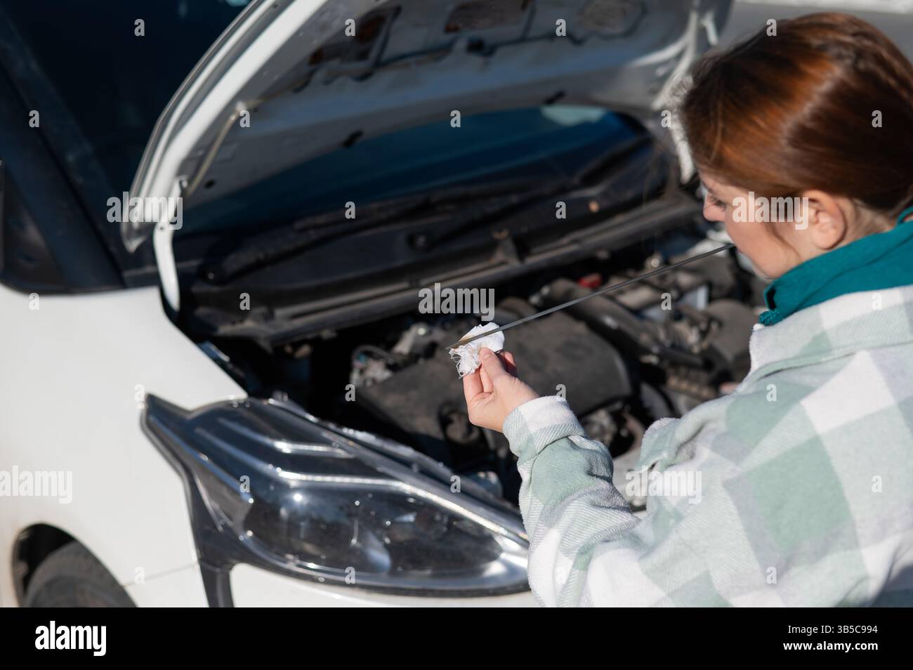 Caucasian female driver checking oil level in car engine Stock Photo - Alamy