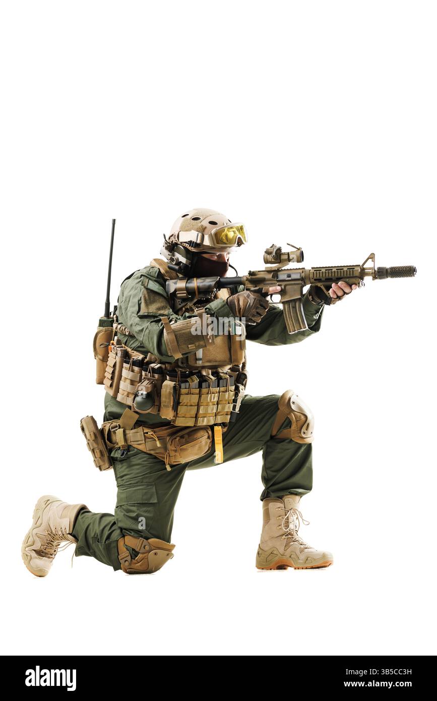 A soldier equipped with military gear and rifle kneeling in a defensive ...