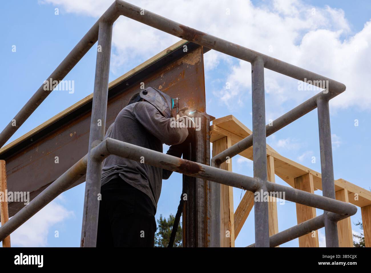 Workers skillfully weld steel beams together at busy construction site ...