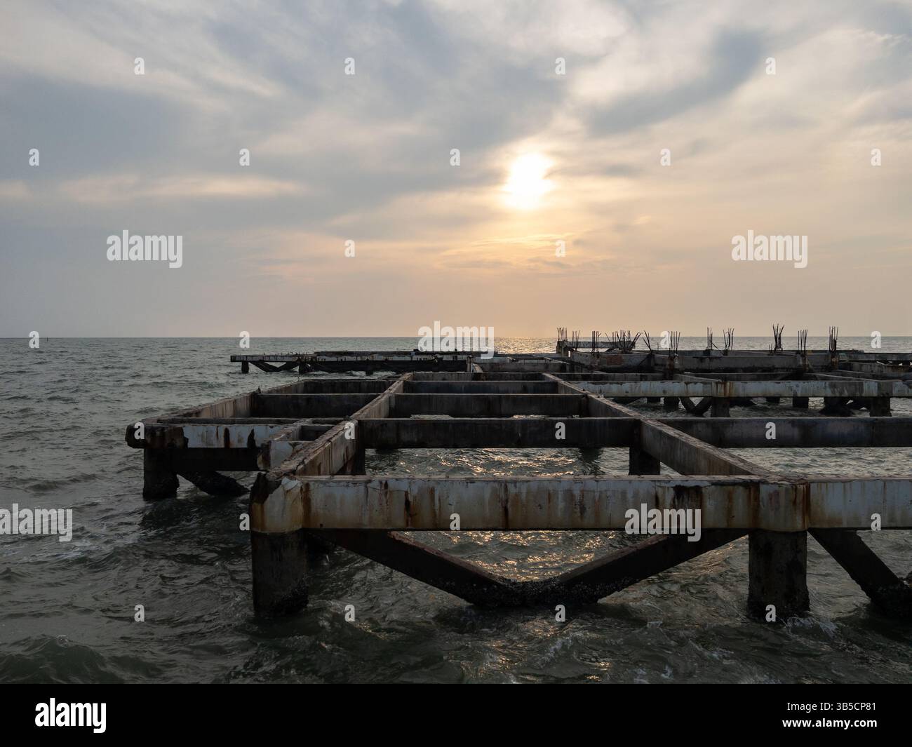 Rugged unfinished pier foundation with concrete piles in the ocean ...